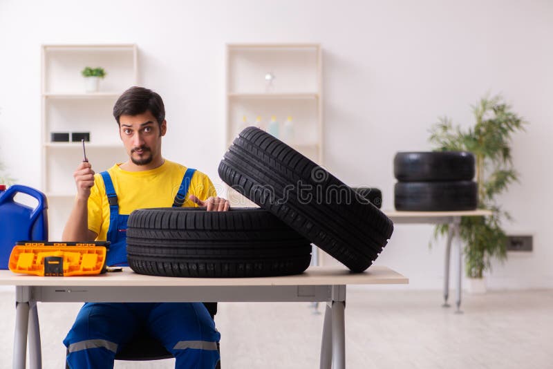 Young Male Garage Worker with Tyre at Workshop Stock Image - Image of ...