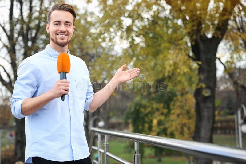 Young Male Journalist with Microphone Working. Space for Text Stock ...
