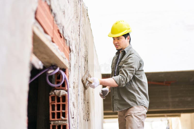 Young Male Labor Plastering on Wall with Mortar at Construction Site ...