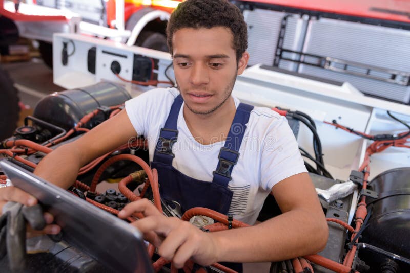 Young Male Mechanic Using Tablet while Working on Industrial Vehicle ...