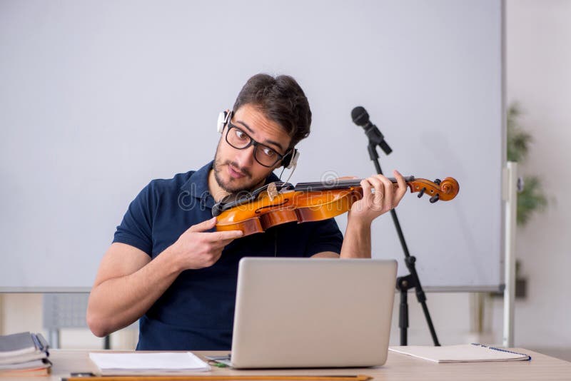 Young Male Music Teacher Sitting in the Classroom Stock Image - Image ...