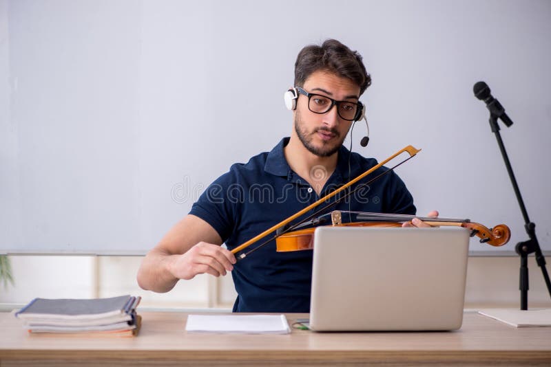 Young Male Music Teacher Sitting in the Classroom Stock Photo - Image ...