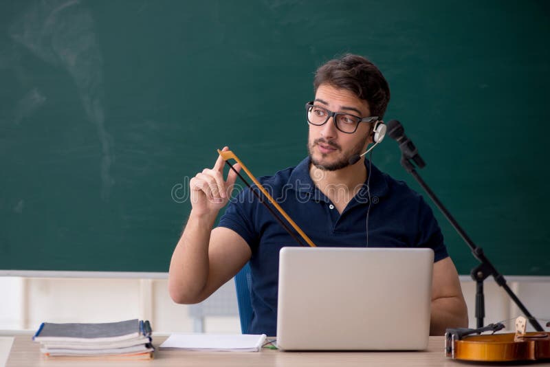 Young Male Music Teacher Sitting in the Classroom Stock Image - Image ...