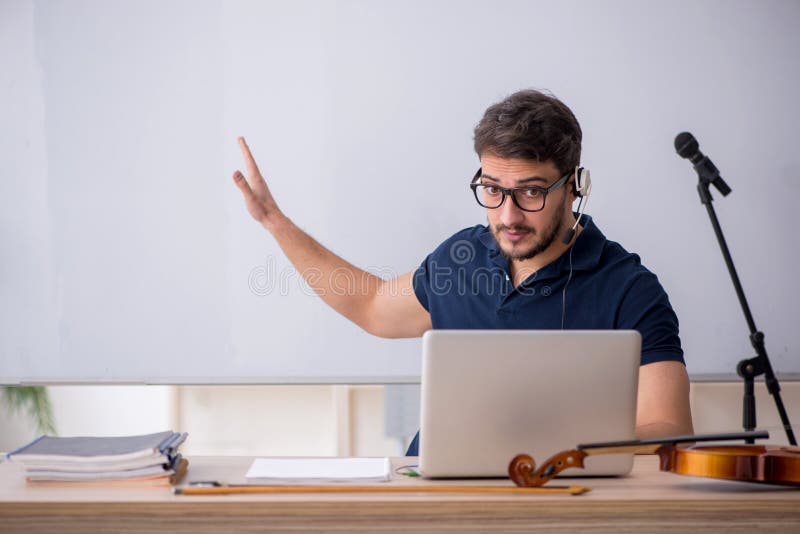 Young Male Music Teacher Sitting in the Classroom Stock Photo - Image ...