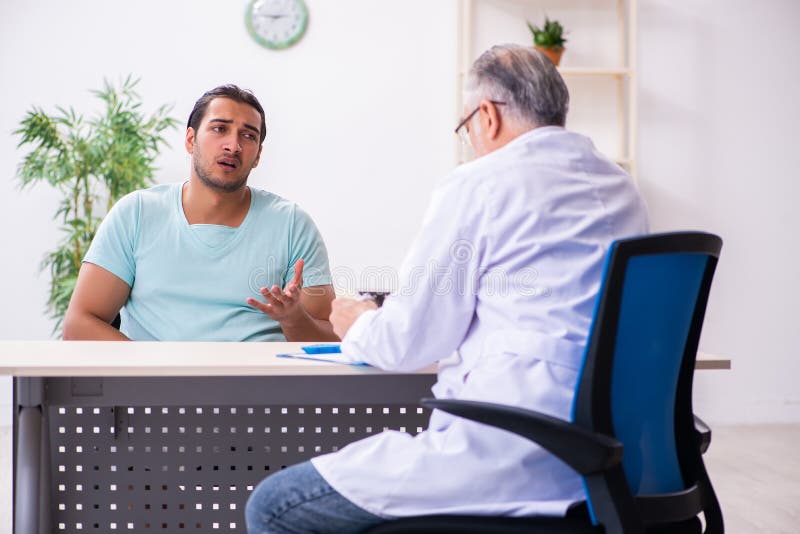 Young Male Patient Visiting Experienced Doctor Stock Photo - Image of ...