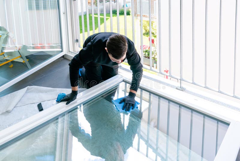 Young Male Professional Cleaner Cleaning a Large Fold-down Window Stock ...