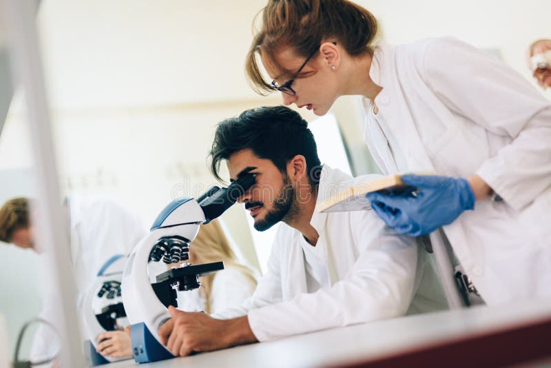 Young Scientist Looking through Microscope in Laboratory Stock Image ...