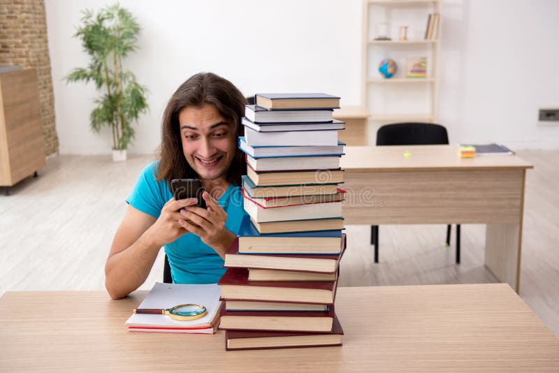 Young Male Student and a Lot of Books in the Class Stock Photo - Image ...