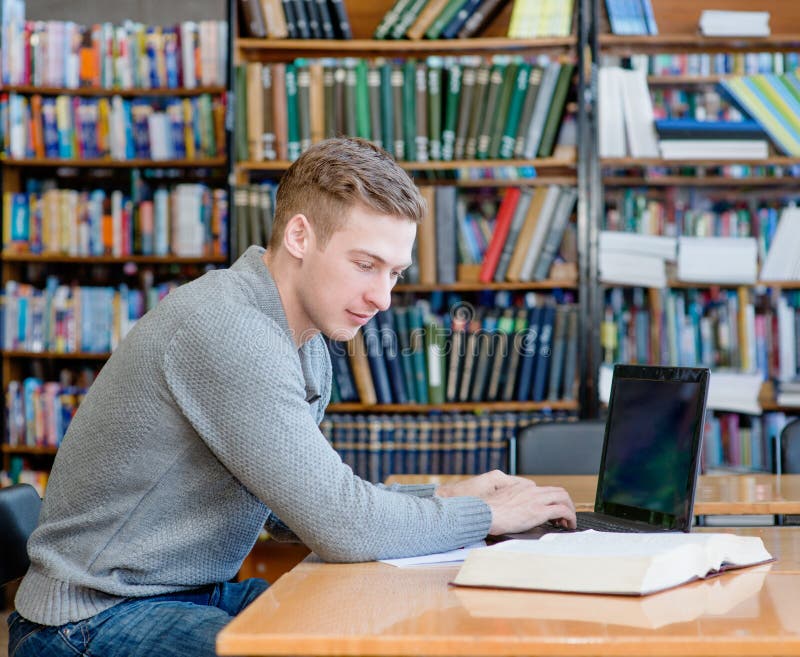 Young Male Student Using Laptop in the University Library Stock Photo ...