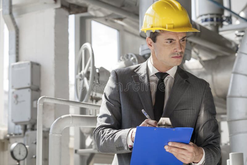 Young Male Supervisor Writing on Clipboard in Industry Stock Photo ...