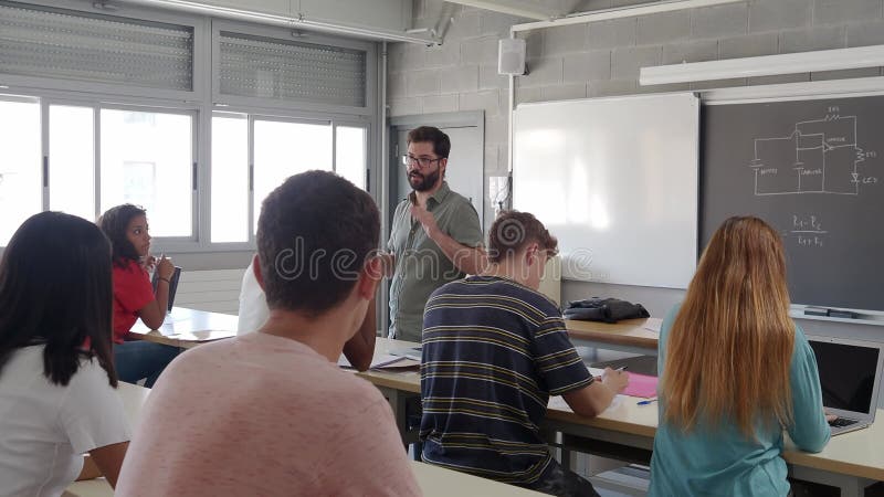 Young Male Teacher Giving a Science Class Explaining at the Blackboard ...