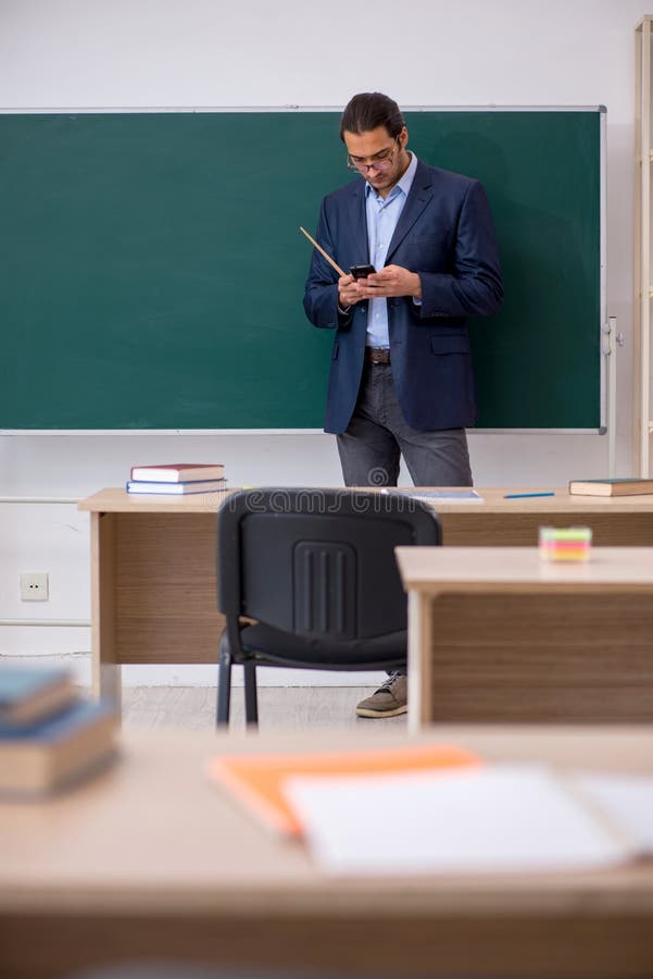 Young Male Teacher in Front of Green Board Stock Photo - Image of phone ...