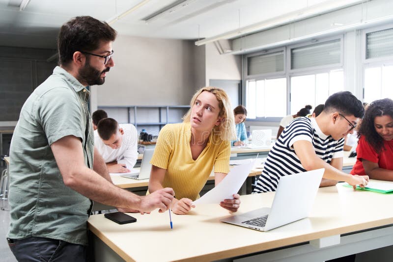 Young Male Teacher Helping Female Student in Class. the Tutor Helping ...