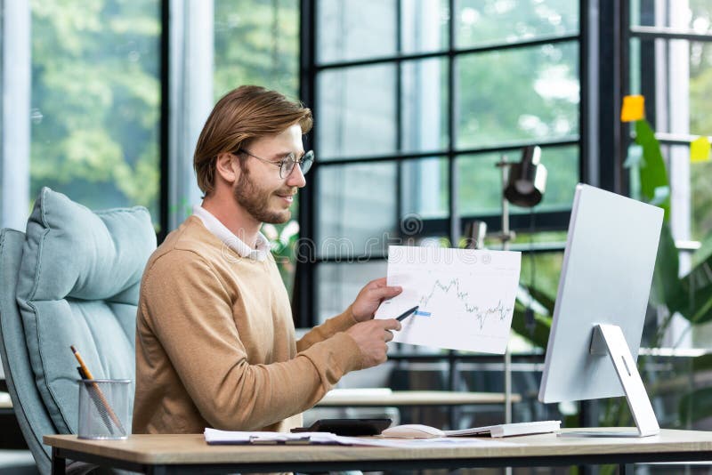 A Young Man Accountant, Expert, Analyst Works at the Desk in the Office ...