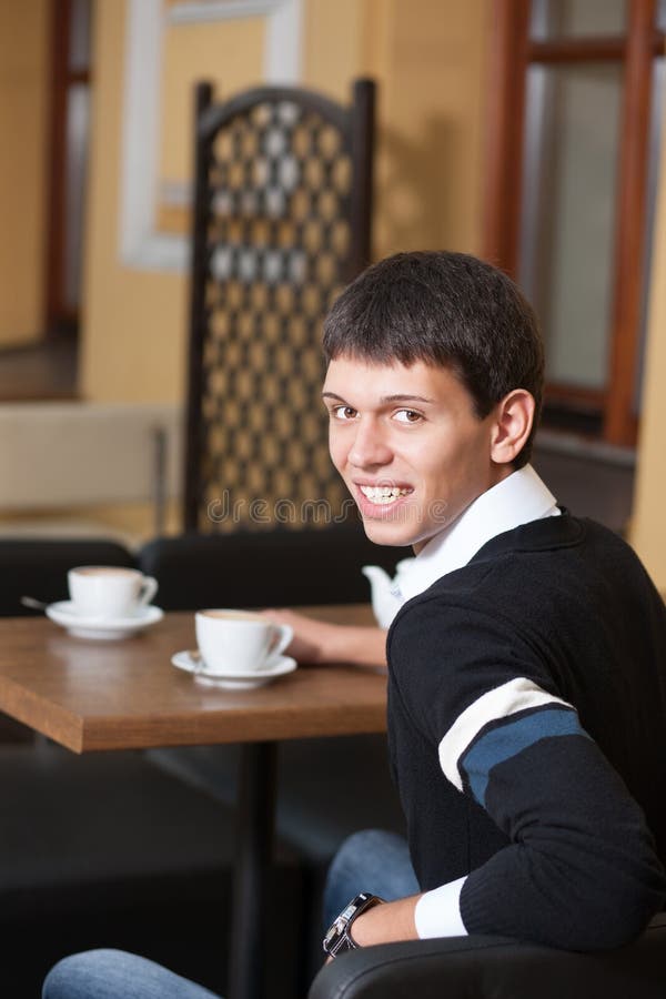 Young Man Across Table with Cup of Coffee Stock Image - Image of coffee ...