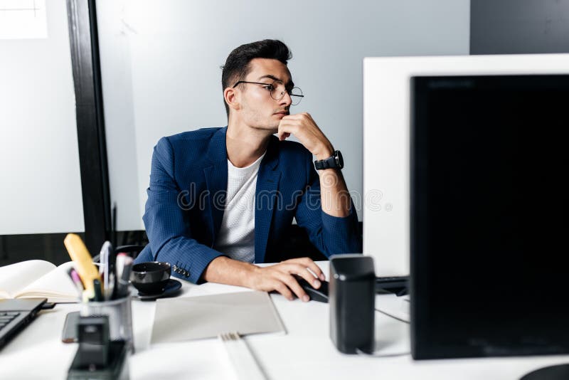 Young Man Architect in Glasses Dressed in a Business Suit Sits at a ...