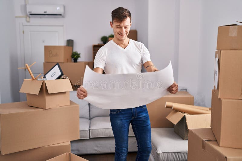 Young Man Architect Smiling Confident Reading House Plans at New Home ...