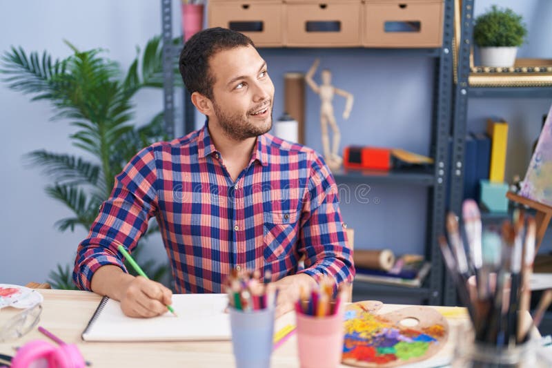 Young Man Artist Smiling Confident Drawing on Notebook at Art Studio ...