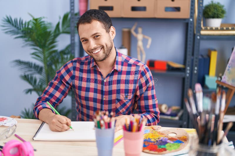 Young Man Artist Smiling Confident Drawing on Notebook at Art Studio ...
