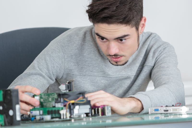 Young Man Assembling Electronics Components at Desk Stock Image - Image ...