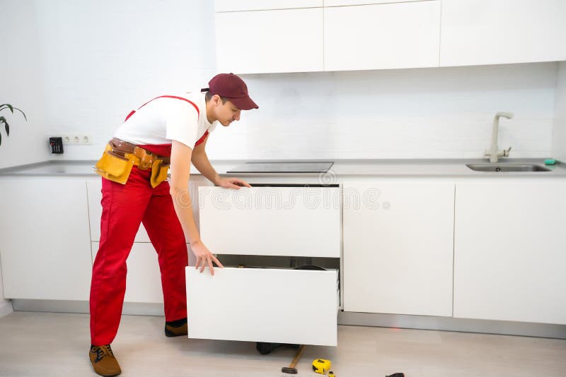 Young Man Assembling Kitchen Furniture. Stock Image - Image of ...