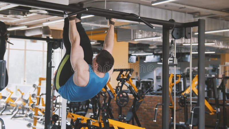 Young Man Athlete Doing Pull-up Bar Abdominal Exercise in Gym Stock ...