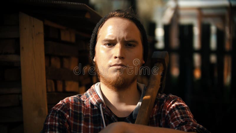 Young Man with Ax Standing in Front of the Camera and Looking in the ...