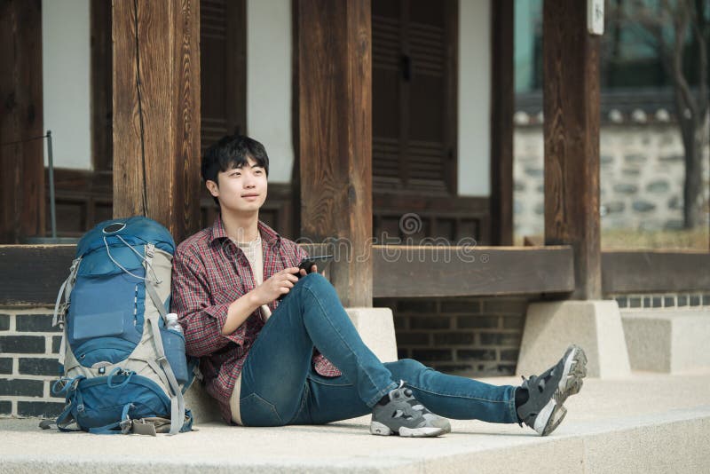 Young Man Backpacking in Korea. Sitting in a Korean Traditional House ...