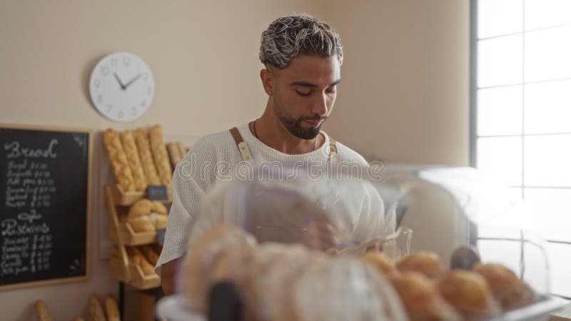 Young Man in a Bakery Shop, Writing Notes Behind the Counter ...
