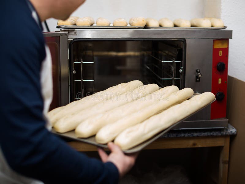 Young man baking bread stock photo. Image of catering - 73557200