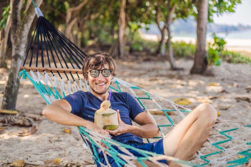 Young Man on the Beach in a Hammock with a Drink Stock Photo - Image of ...