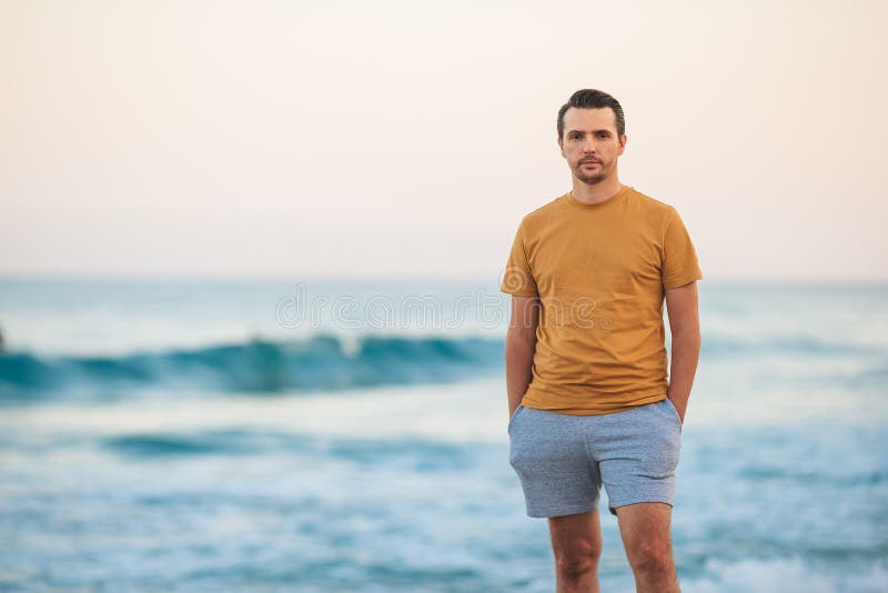 Young Man Walking on the Beach at Sunset Stock Photo - Image of summer ...