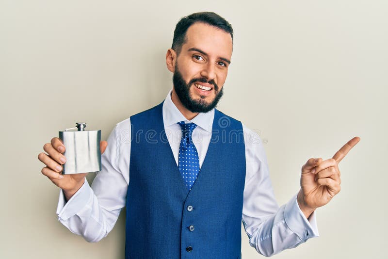 Young Man with Beard Drinking Whiskey from Flask Smiling Happy Pointing ...