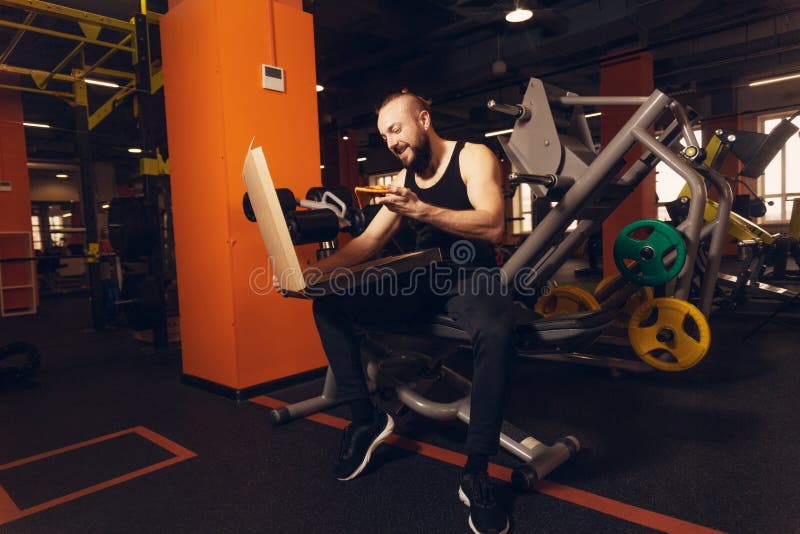 A Young Man with a Beard is Happy To Eat Pizza in the Gym Stock Image ...