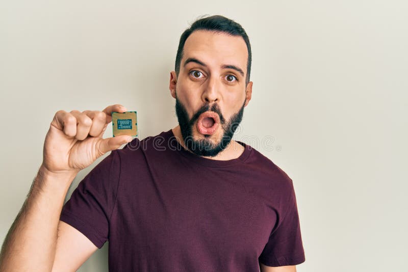 Young Man with Beard Holding Cpu Computer Processor Scared and Amazed ...