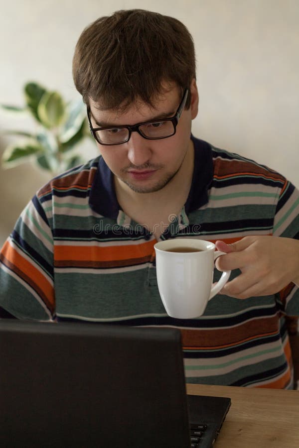 Young Man Behind a Laptop Drinking Tea Stock Photo - Image of casual ...