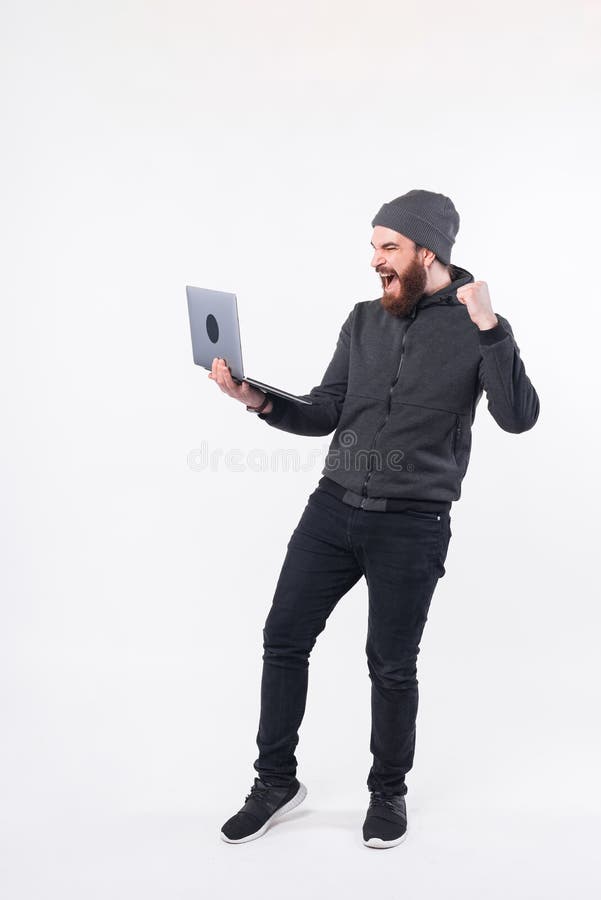A Young Man is Being Very Excited Looking at His Computer Near a White ...