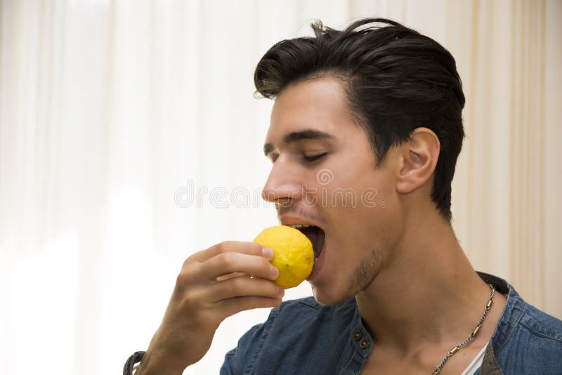Young man biting lemon stock image. Image of looking - 45142923