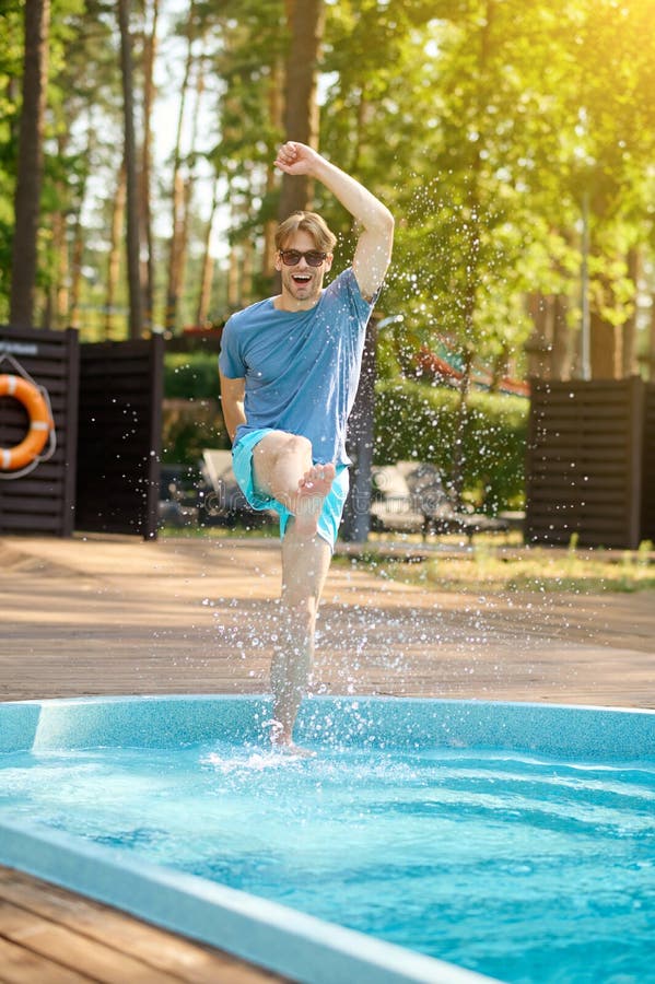 A Young Man in a Blue Tshirt and Sunglasses Having Fun at the Swimming ...