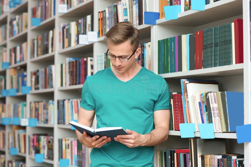 Young Man with Book Near Shelving Unit Stock Image - Image of education ...