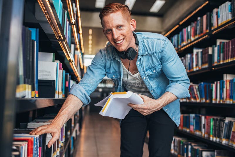 Young Man at Bookshelf at Public Library Stock Image - Image of taking ...