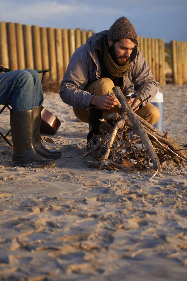 Hell Get it Started. a Young Man Building a Fire on the Beach. Stock ...