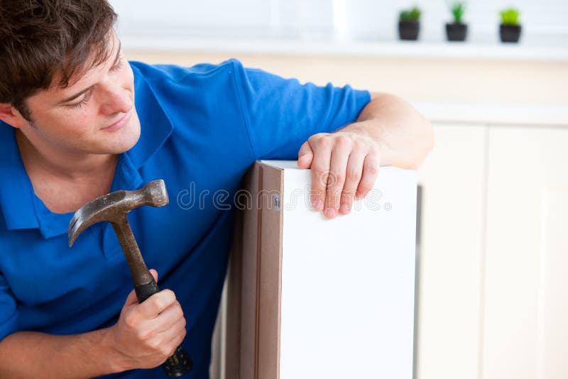 Young Man Building Furniture Using Hammer and Nail Stock Photo - Image ...