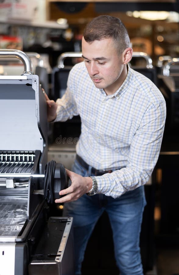 Young Man Chooses BBQ Grill in Store Stock Photo - Image of client ...