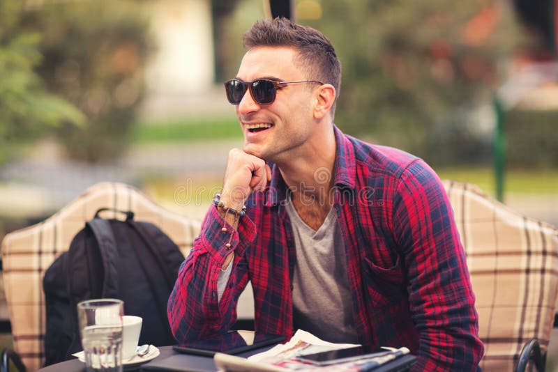 Young man at a cafe table stock image. Image of quality - 81600439