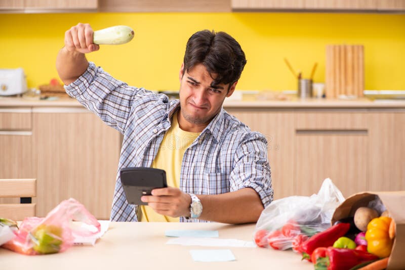 The Young Man Calculating Expences for Vegetables in Kitchen Stock ...