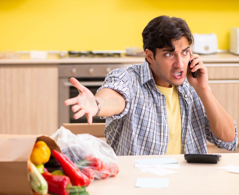 Young Man Calculating Expences for Vegetables in Kitchen Stock Image ...
