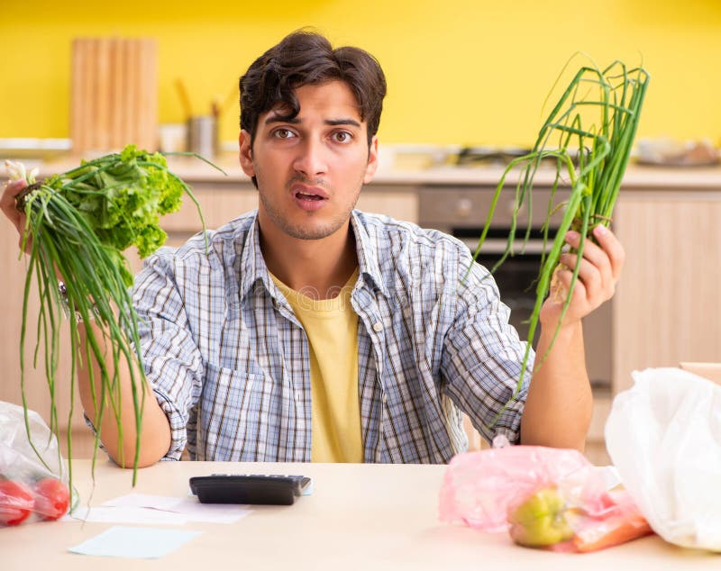 Young Man Calculating Expences for Vegetables in Kitchen Stock Photo ...