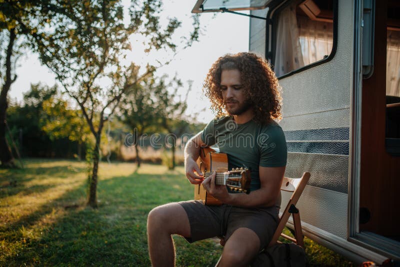 Young Man is on a Camping Trip in Nature Alone, Sitting in Front ...