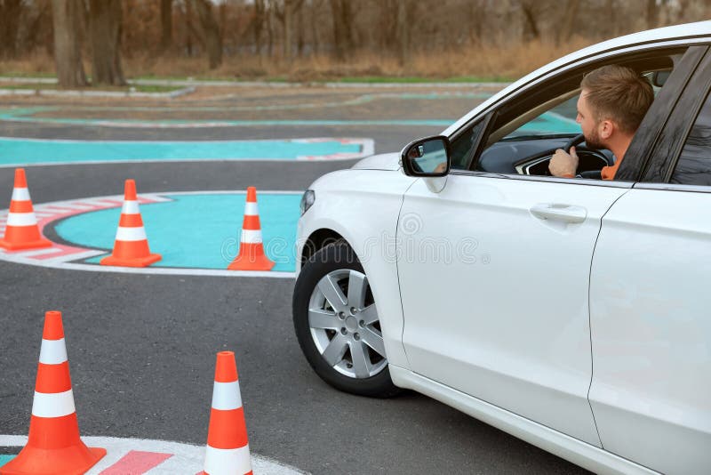 Young Man in Car on Test Track with Traffic Cones. Driving School Stock ...